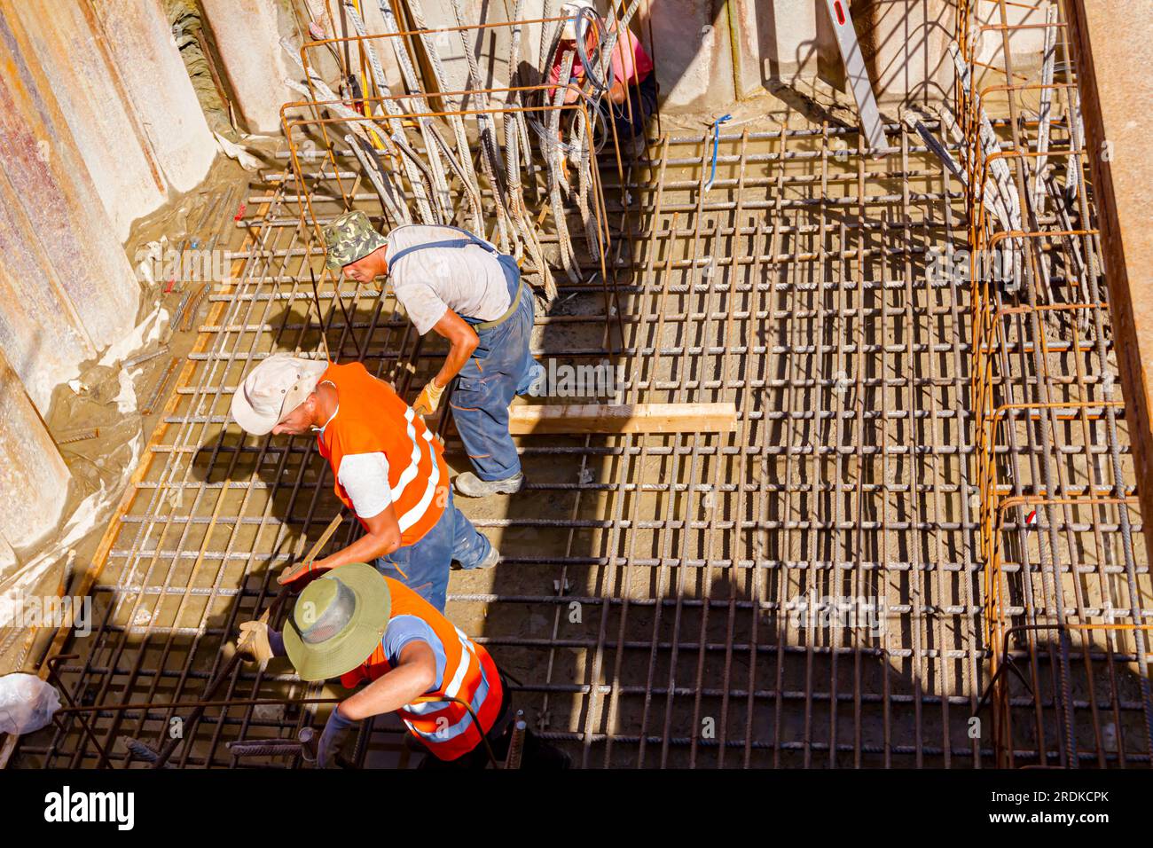 Shot above on workers surrounded by metal piles, who are installing ...
