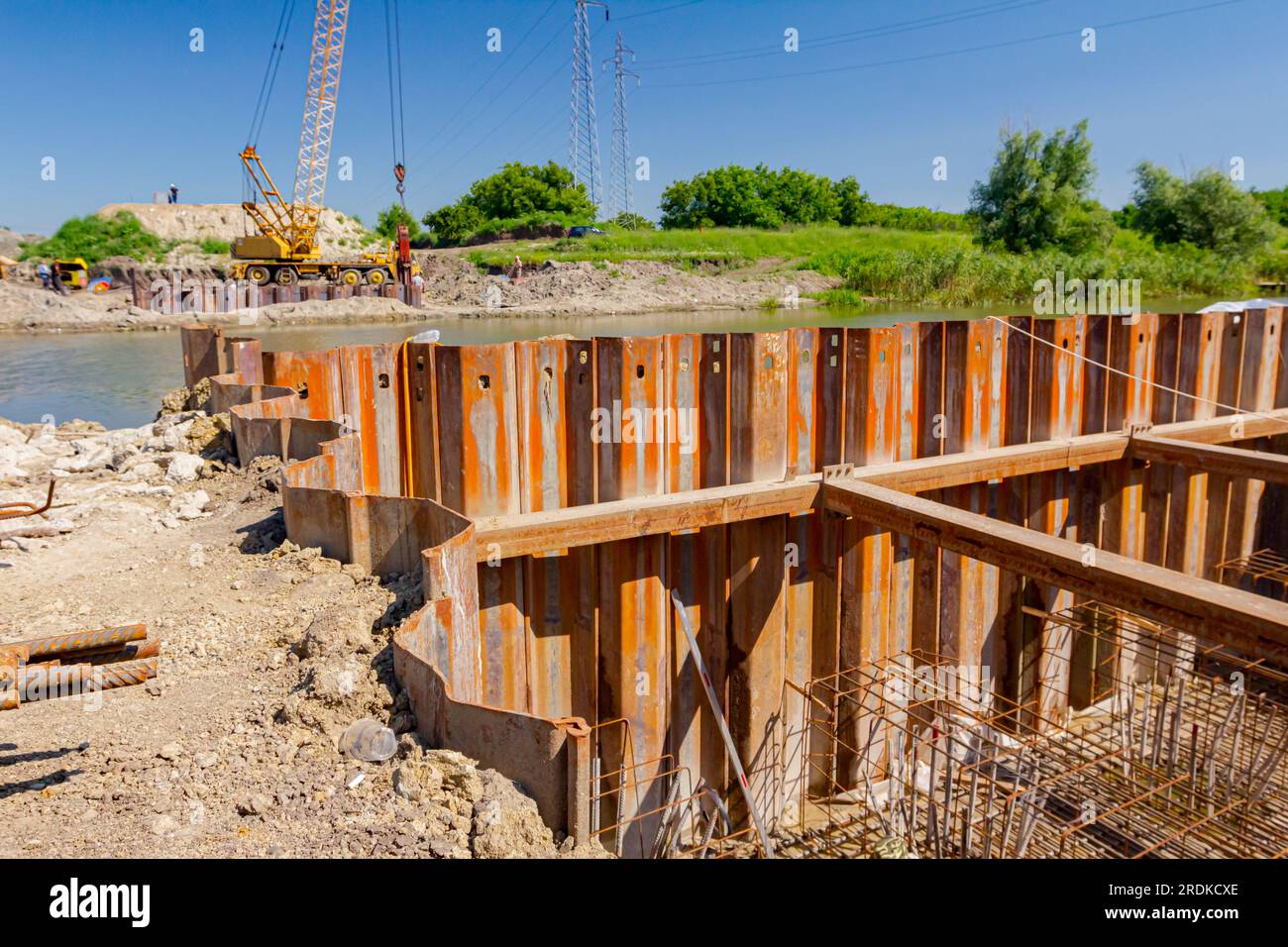Installed rusty metal piles along river bank built in for bridge ...