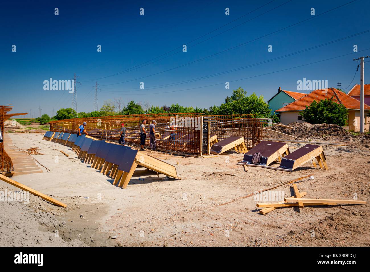 Prepared parts of the bridge mold arranged in line, team of workers are ...