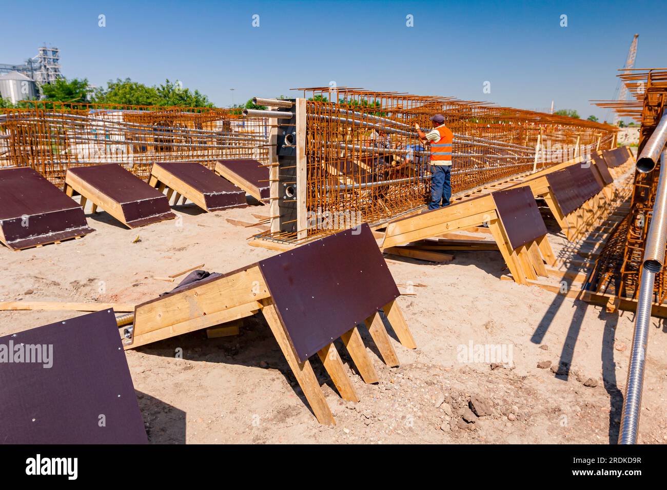 Prepared parts of the bridge mold arranged in line, team of workers are ...