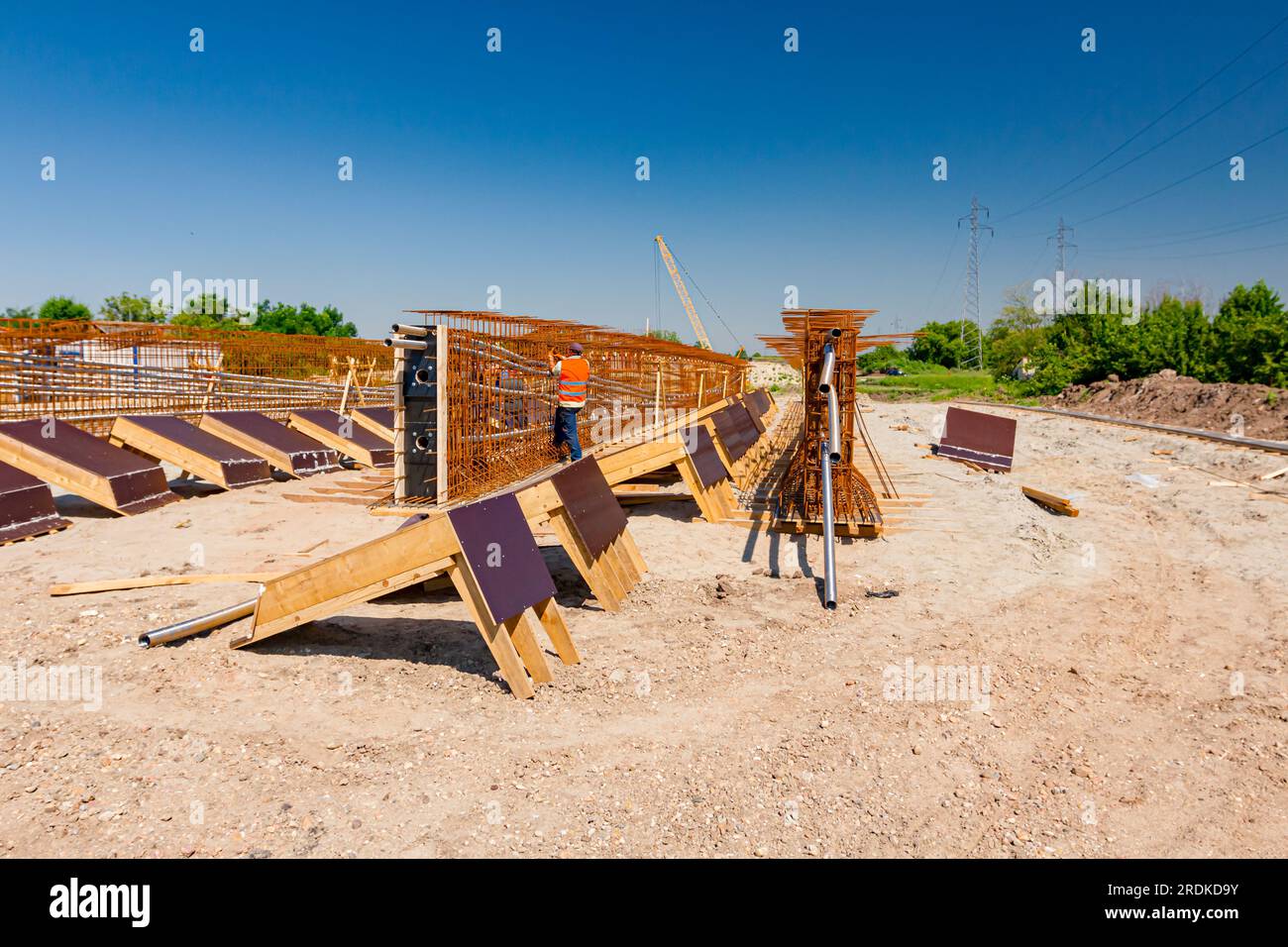 Prepared parts of the bridge mold arranged in line, team of workers are ...