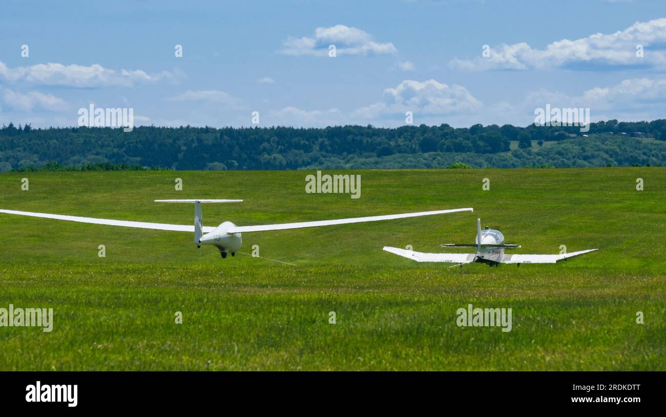 A glider gets pulled by a tug aircraft along a runway in the South of ...