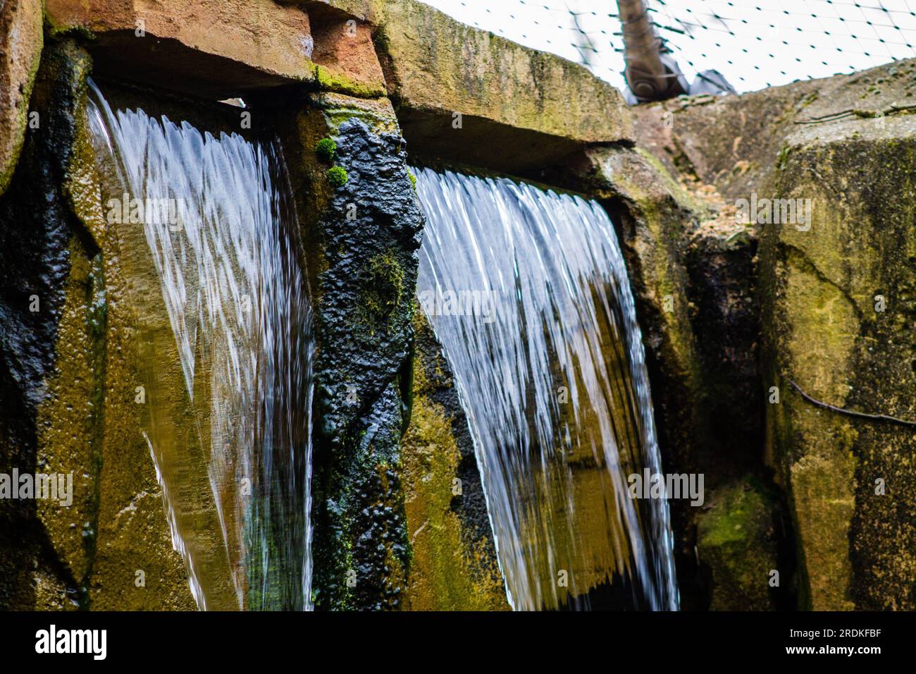 Water flowing from a stone wall, closeup of a waterfall Stock Photo - Alamy