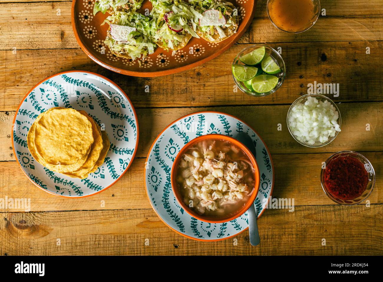 Pozole served in a deep dish, with tostadas, salsa and vegetables on a ...