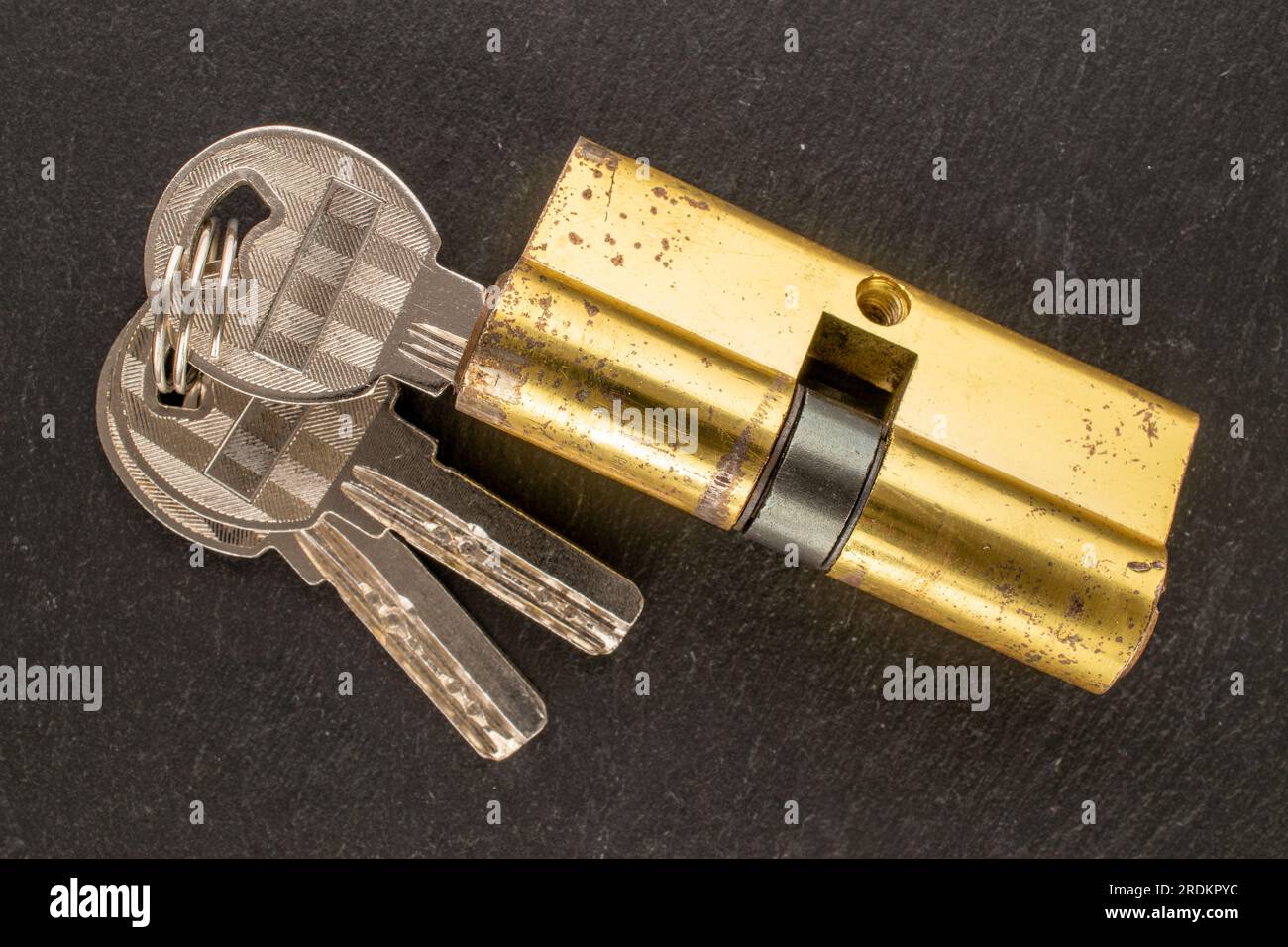 One door lock cylinder and keys on slate stone, macro, top view Stock ...