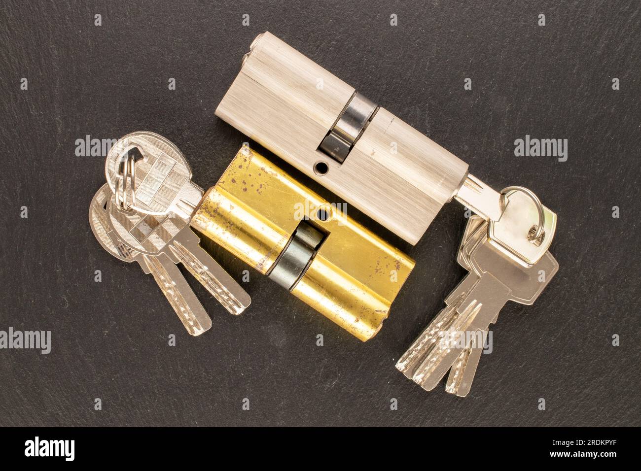 Two door lock cylinders and keys on slate stone, macro, top view Stock ...
