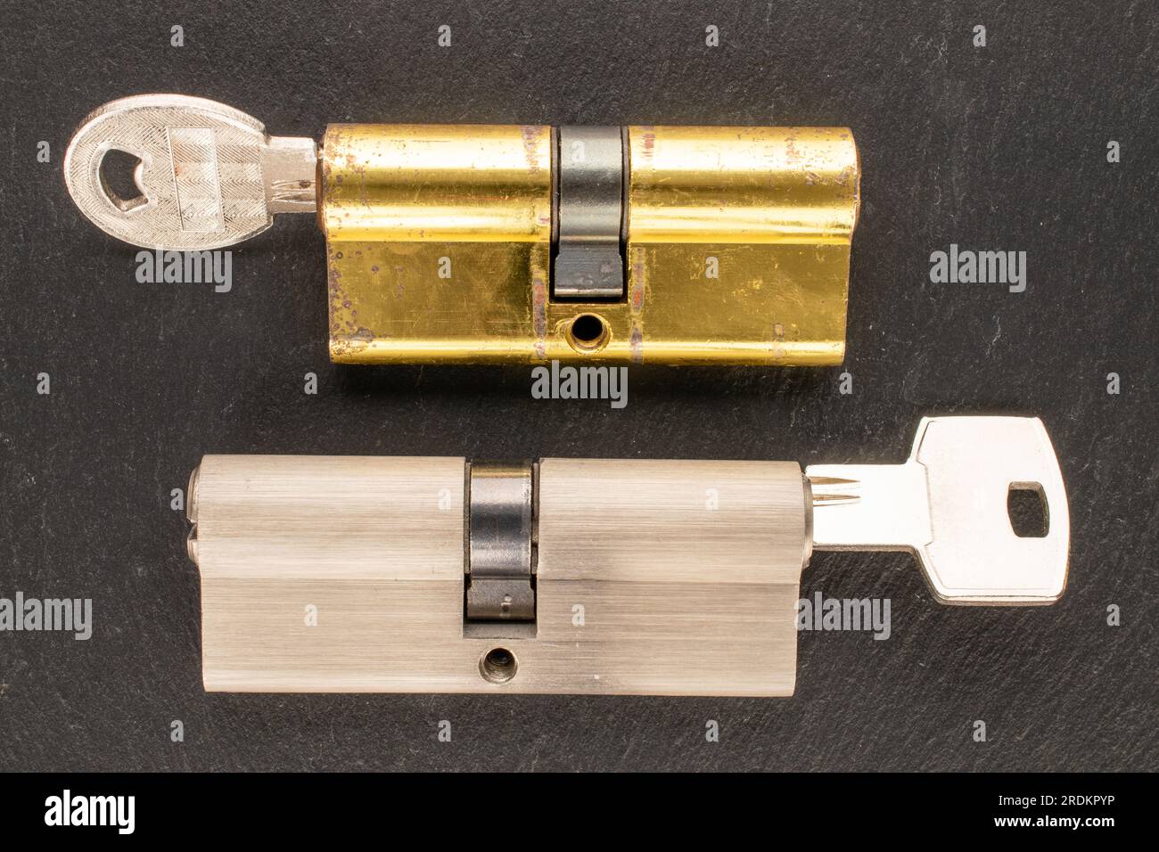 Two door lock cylinders and keys on slate stone, macro, top view Stock ...