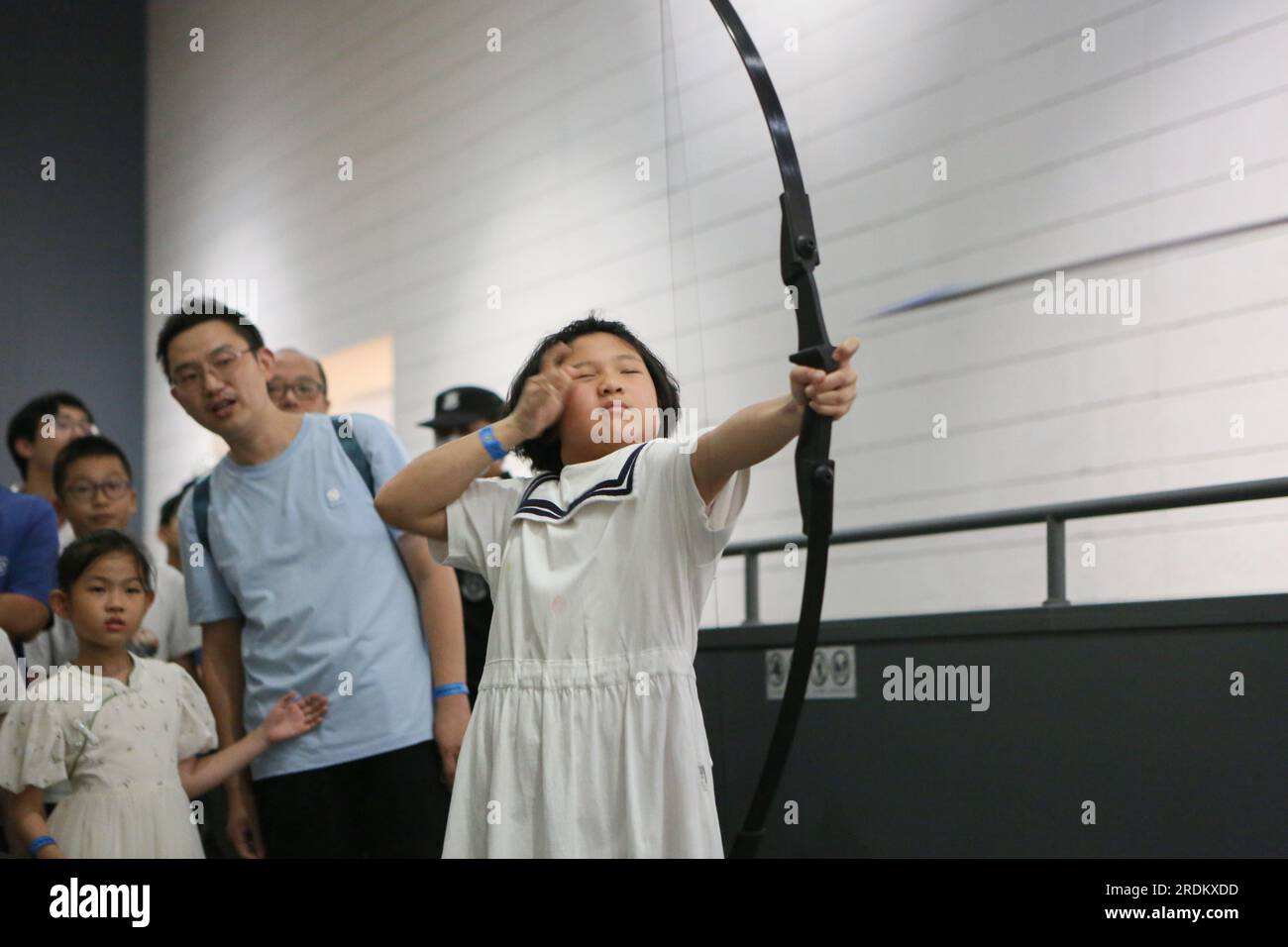 Shanghai. 21st July, 2023. A girl experiences archery at a night fair ...