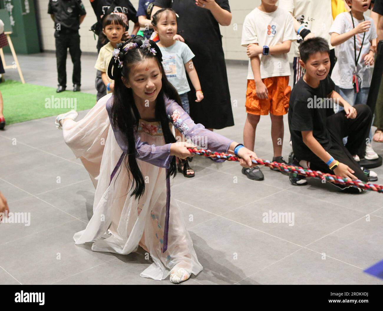 Shanghai. 21st July, 2023. A girl takes part in a traditional tug-of ...