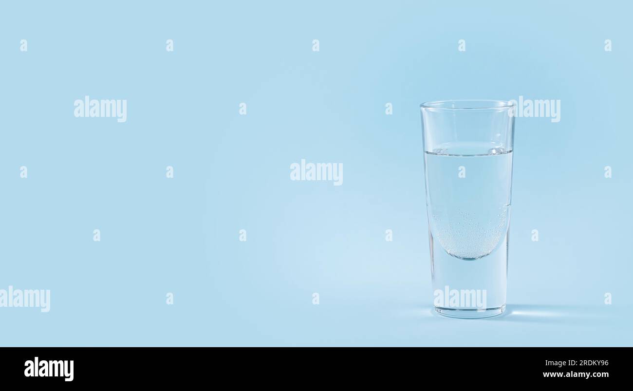 Glass of pure sparkling water on light blue background Stock Photo - Alamy