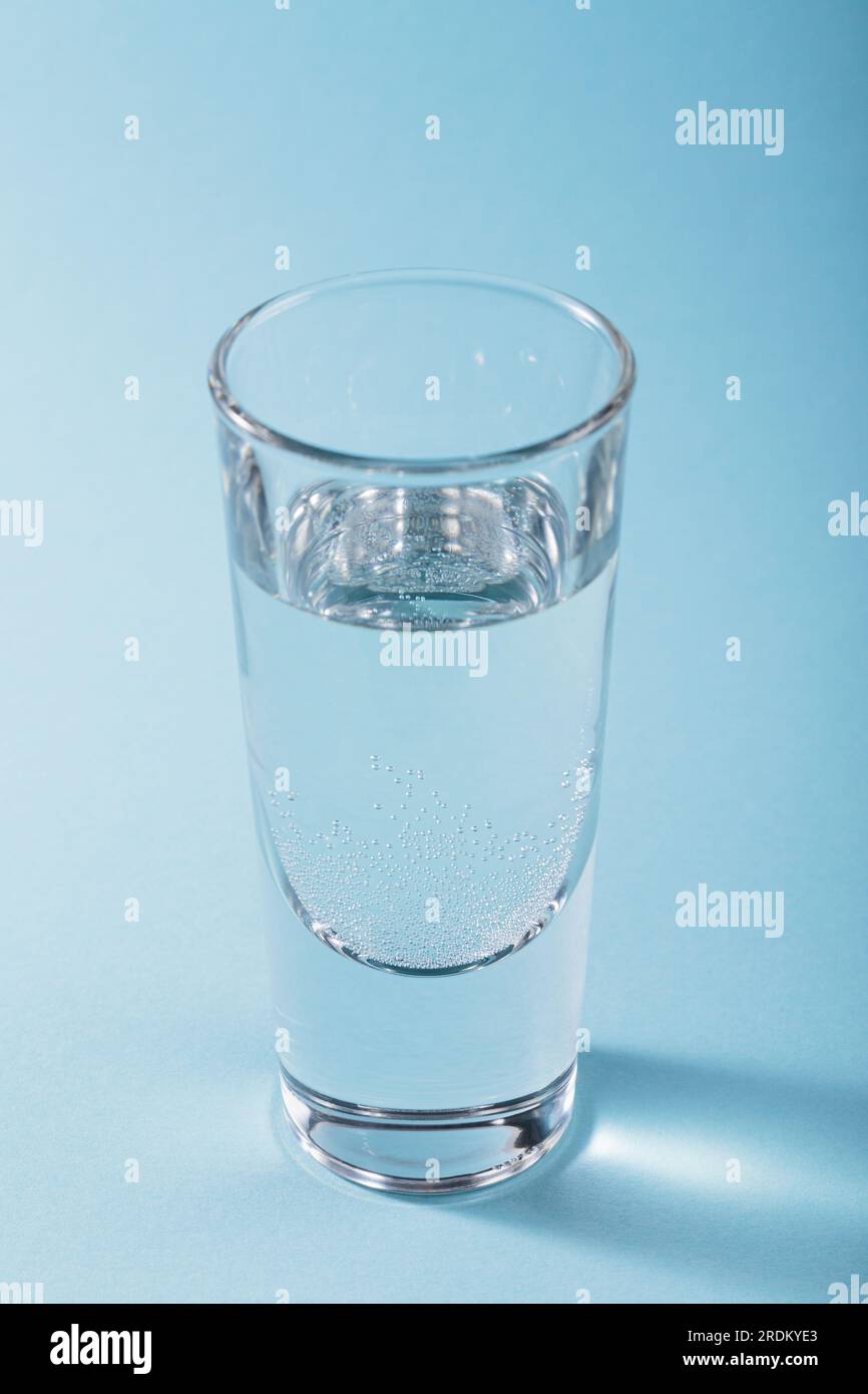 Glass of pure sparkling water on light blue background Stock Photo - Alamy