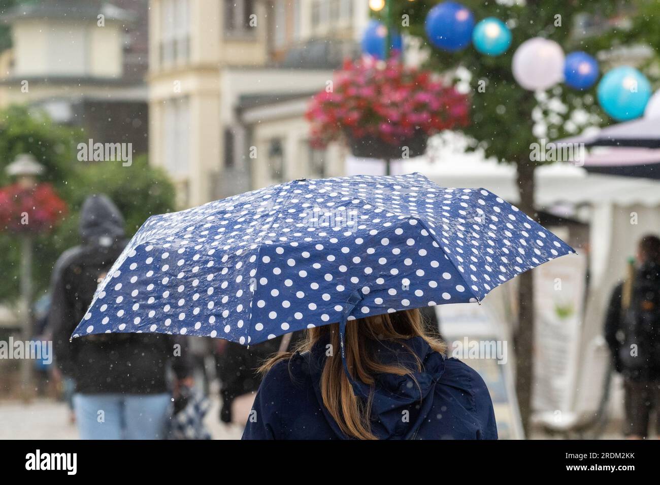 Zinnowitz, Germany. 22nd July, 2023. Tourists walk in the rain on the ...