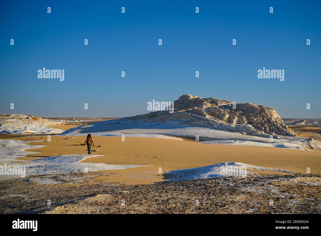 A man seen walking in the White Desert, Egypt. From erosion of volcanos ...