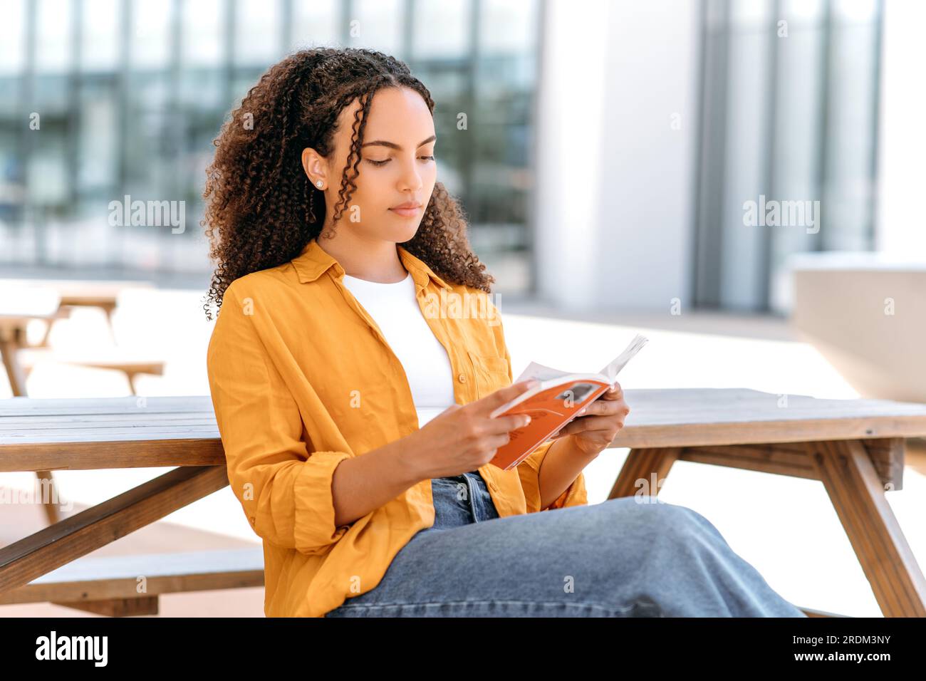 Reading concept. Concentrated brazilian or hispanic curly haired young ...