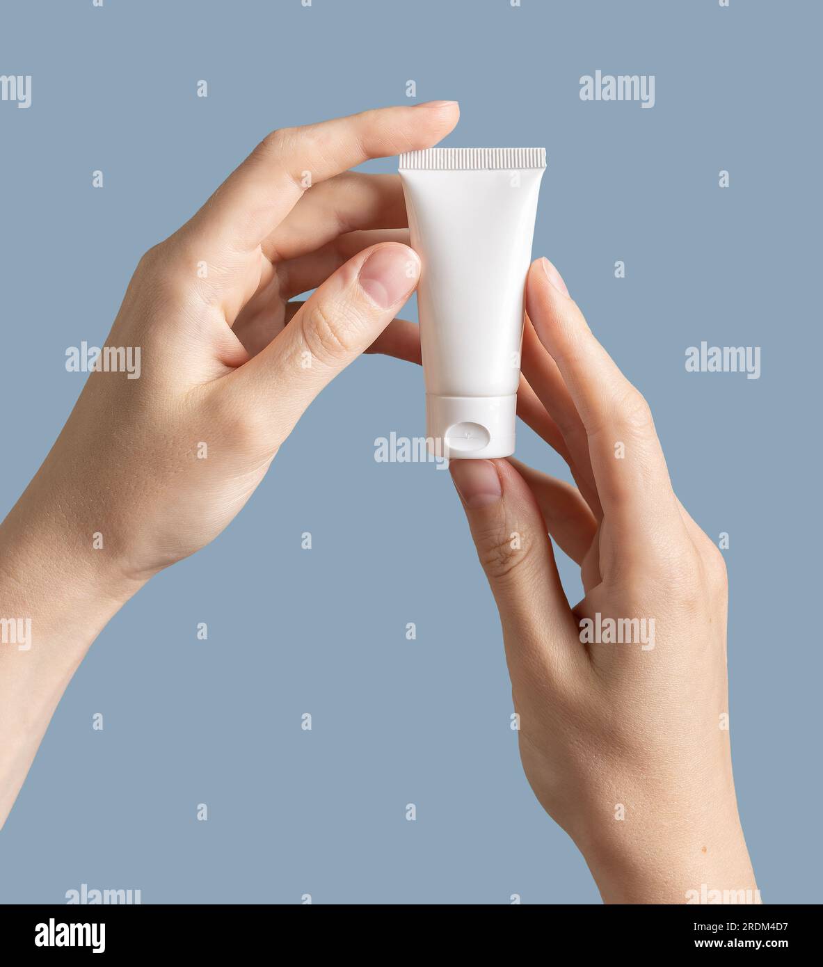 Hand holding cream tube isolated white background Stock Photo - Alamy