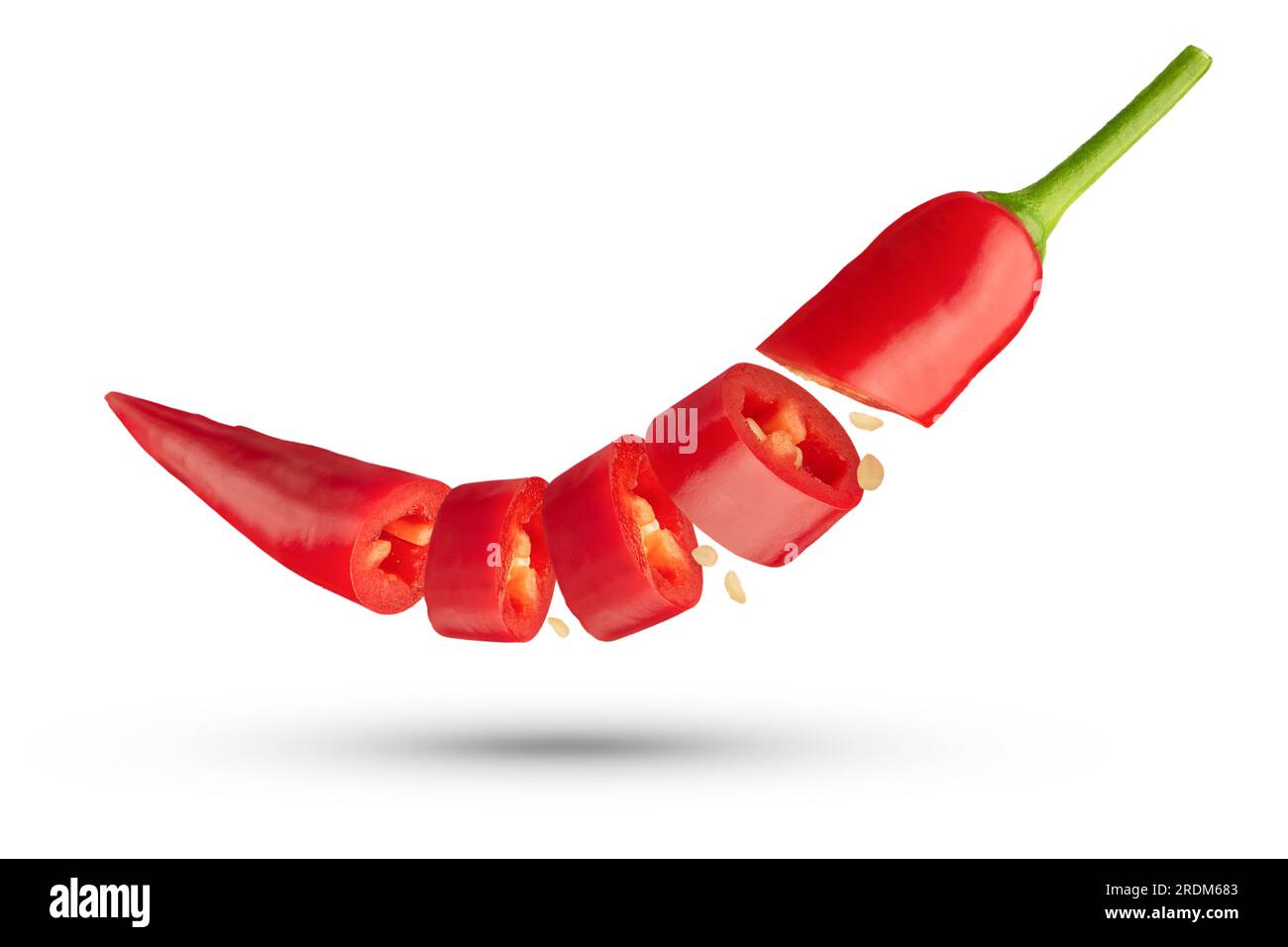 Red chili pepper cut into pieces on a white isolated background. A ...