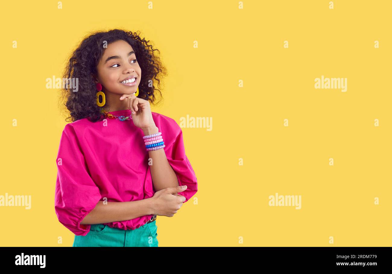 Smiling dark-skinned teenage girl thinks, imagines or has come up with ...