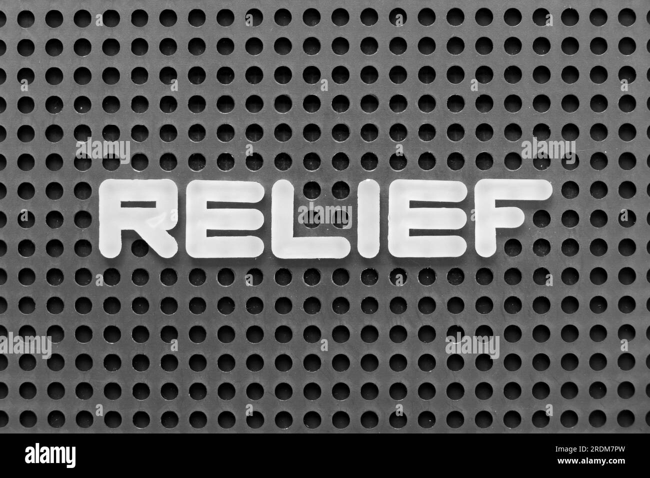 White alphabet letter in word relief on black pegboard background Stock ...