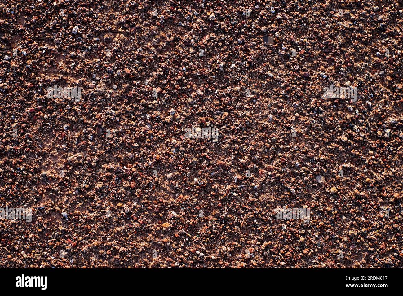 Fine red metal ore rich gravel and sand, flat surface in hard sunset ...
