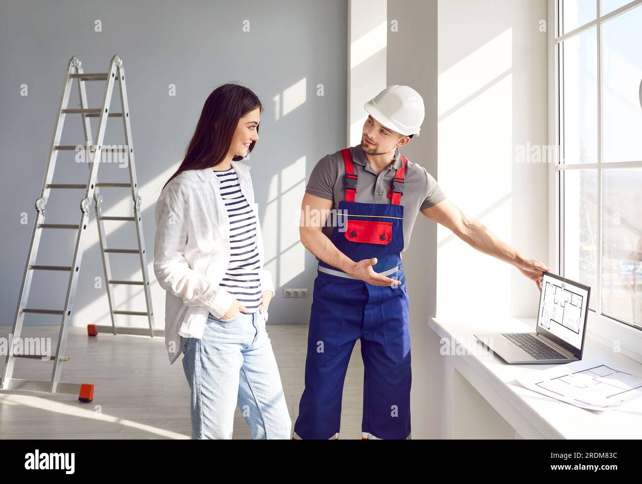 Architect or engineer shows blueprints on laptop and discusses house ... Architect or engineer shows blueprints on laptop and discusses house ...