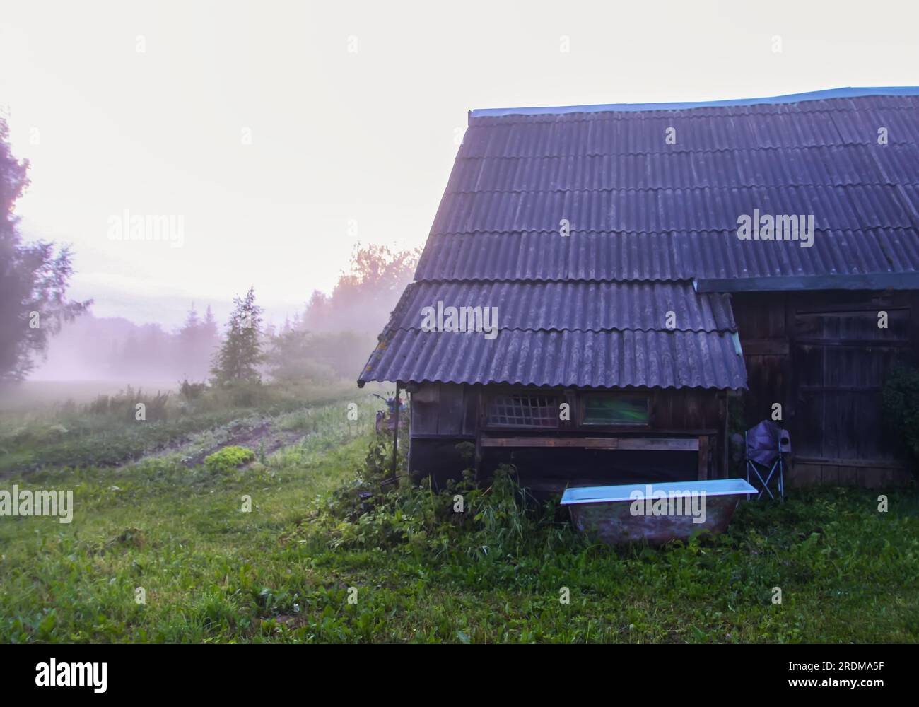 Rural house in a fog in summer evening Stock Photo - Alamy