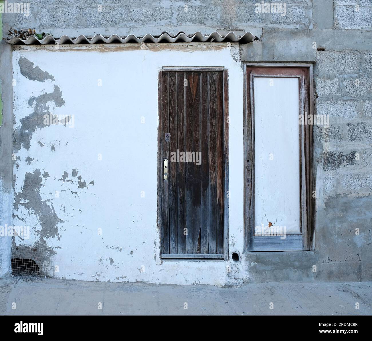Front of a small simple home built of basic inexpensive locally ...