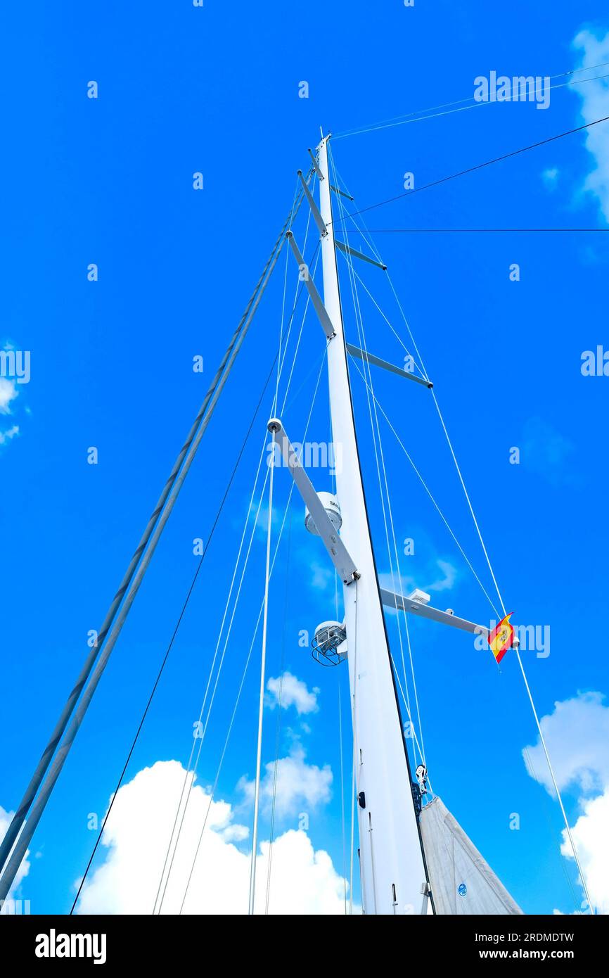 Tall white mast of an ultra modern luxury maxi yacht, furled sails and ...