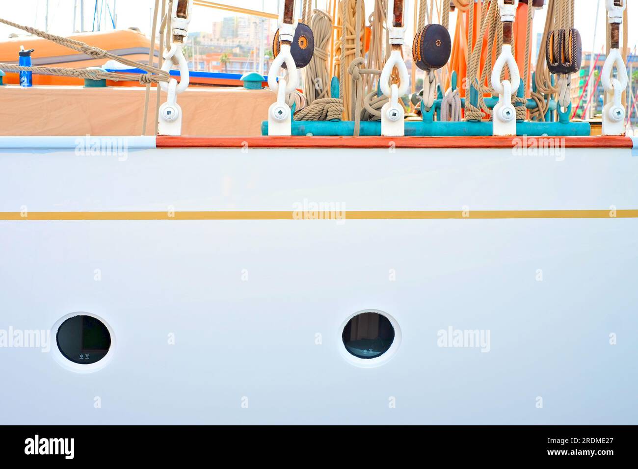 White topside of a luxury sailing yacht with a golden line, round port ...