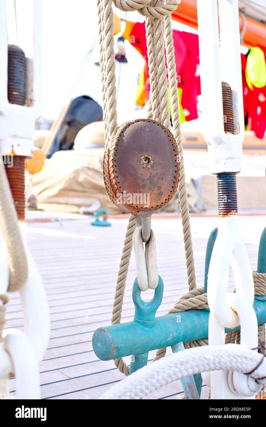 A wooden block and a hempen line, teak deck and deck hardware of a ...