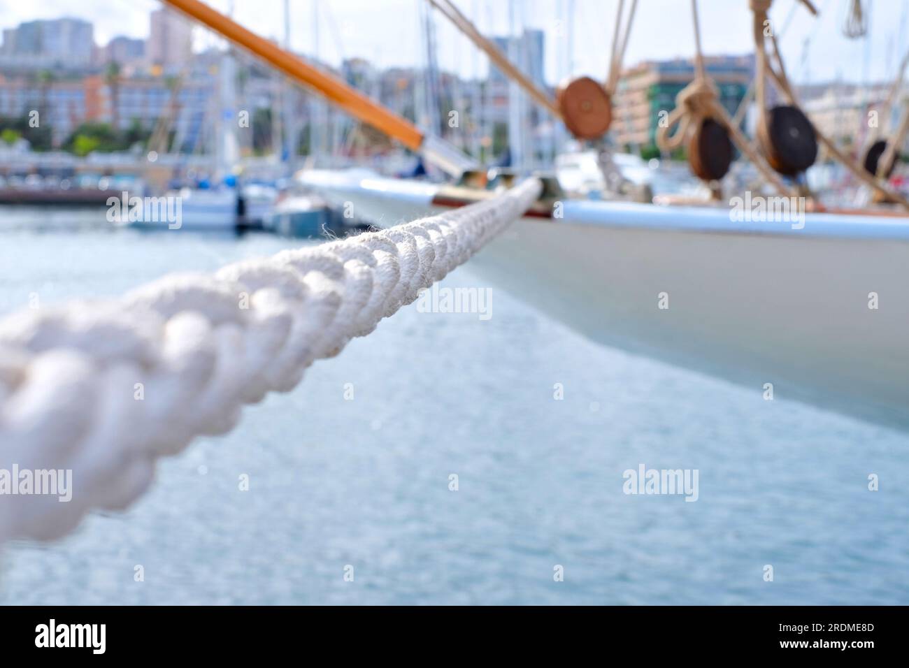 A dock line (a mooring rope) and a blurred stern of a classic sailing ...