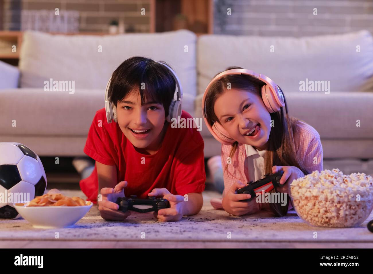 Little children playing video game at home in evening Stock Photo - Alamy