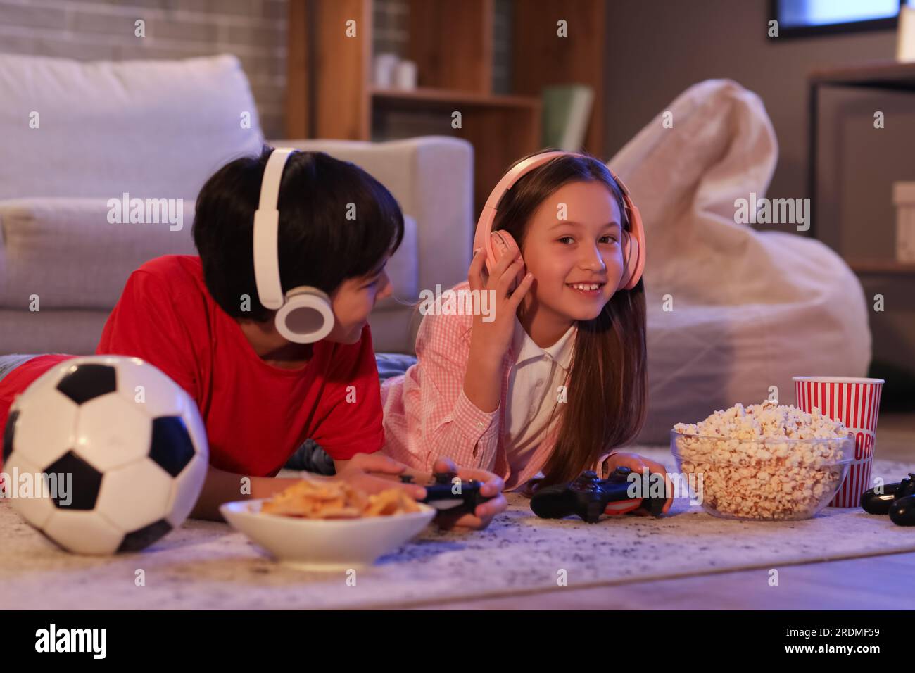 Little children playing video game at home in evening Stock Photo - Alamy
