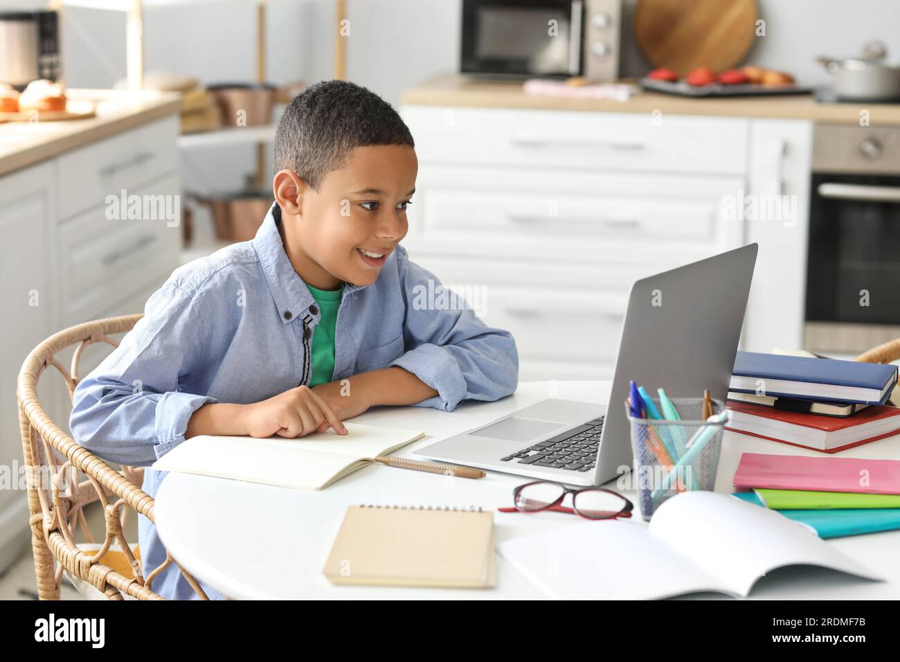 Little African-American boy studying computer sciences online in ...