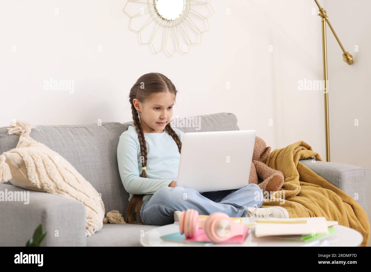 Little girl with laptop studying computer sciences online at home Stock ...