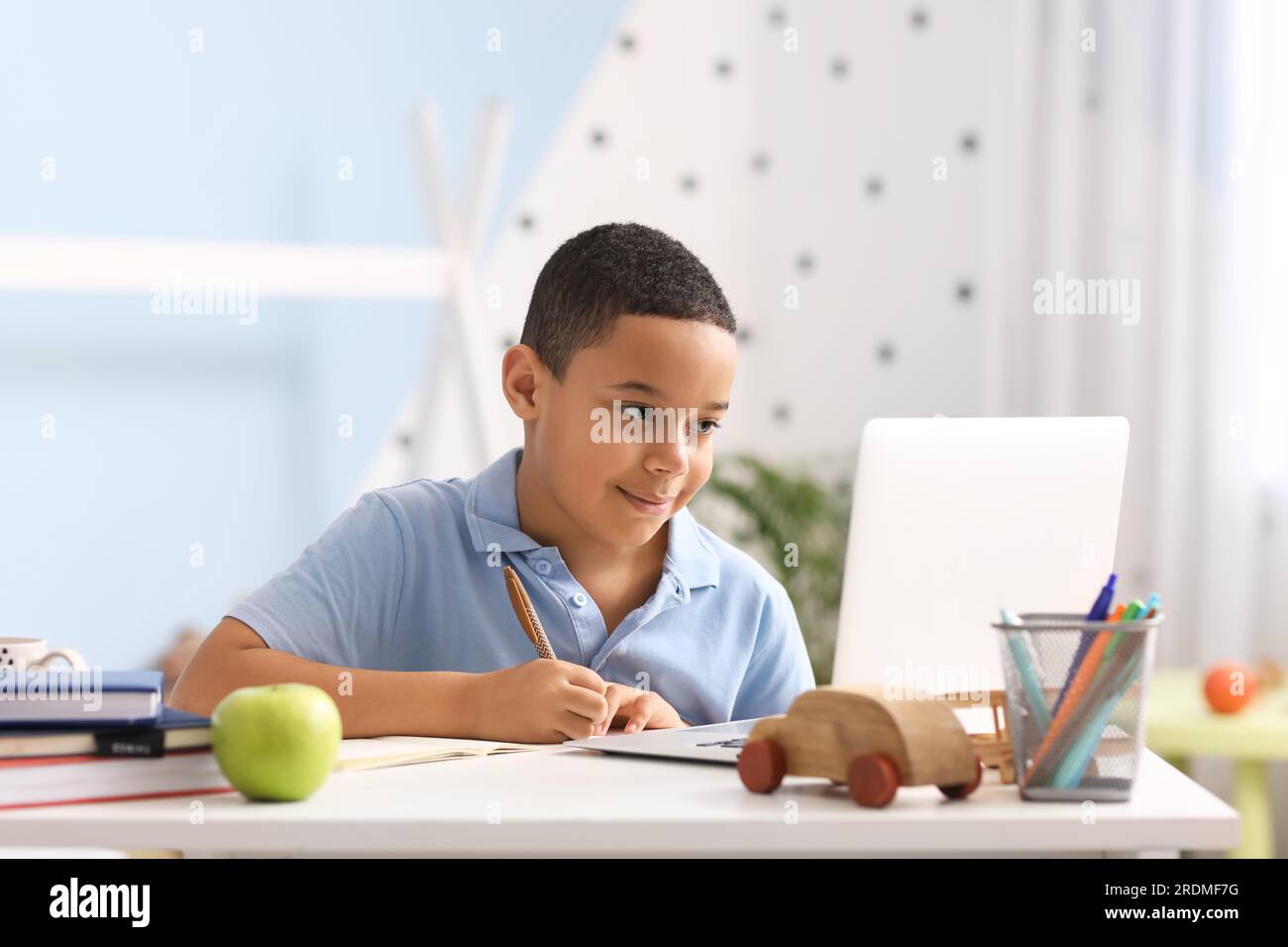 Little African-American boy studying computer sciences online in ...