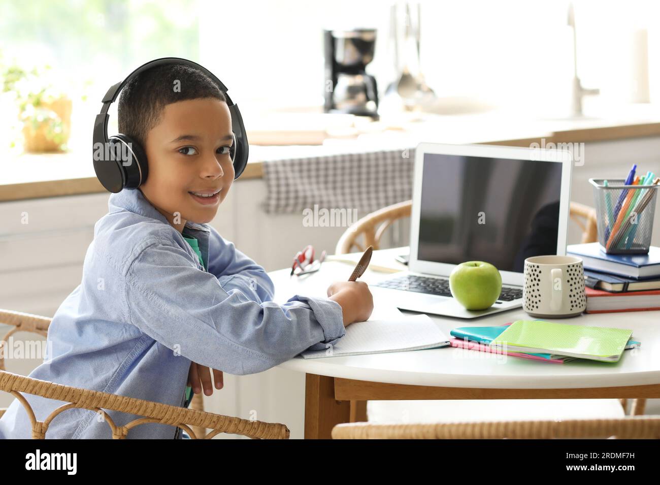 Little African-American boy in headphones studying computer sciences ...