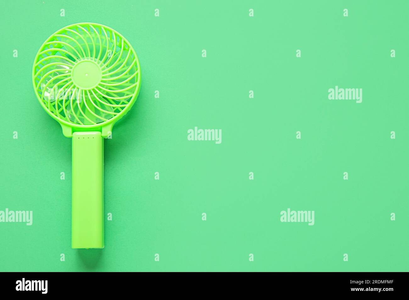 Modern manual fan on green background Stock Photo - Alamy