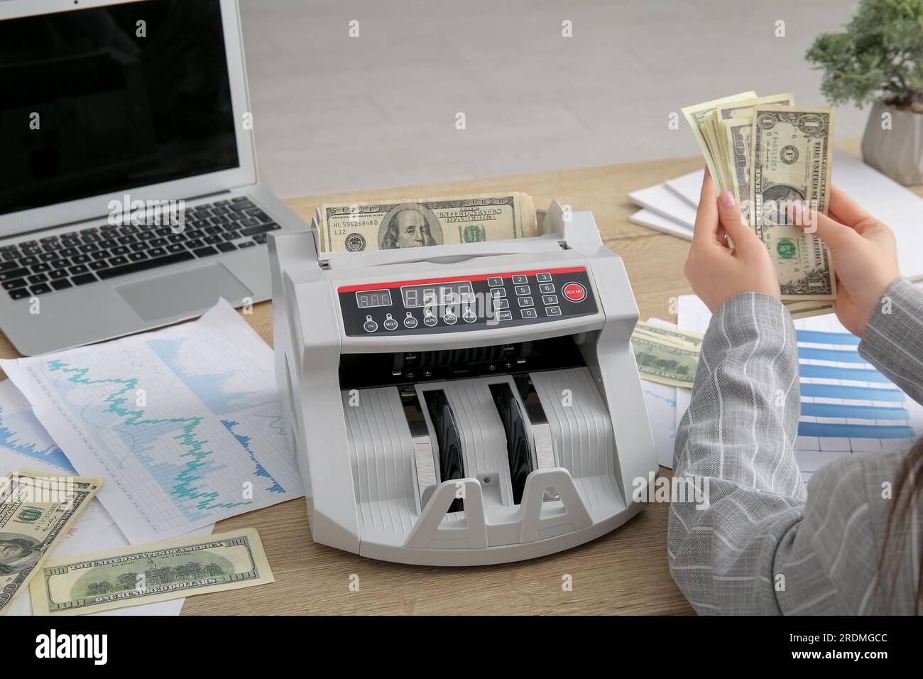 Woman counting money while sitting at table with cash register, closeup ...
