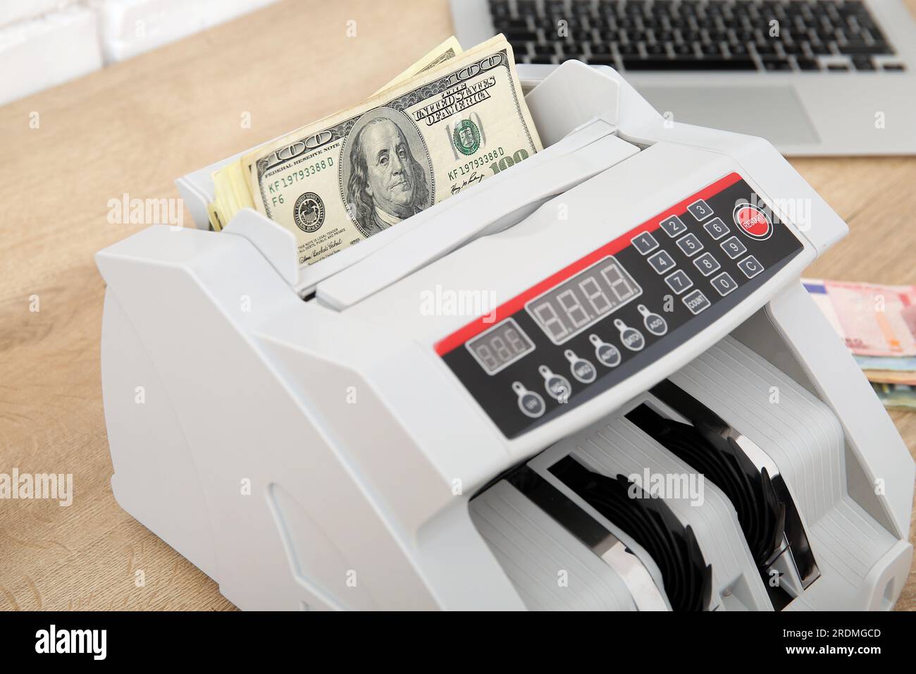 Cash counting machine with dollar banknotes on table in office, closeup ...
