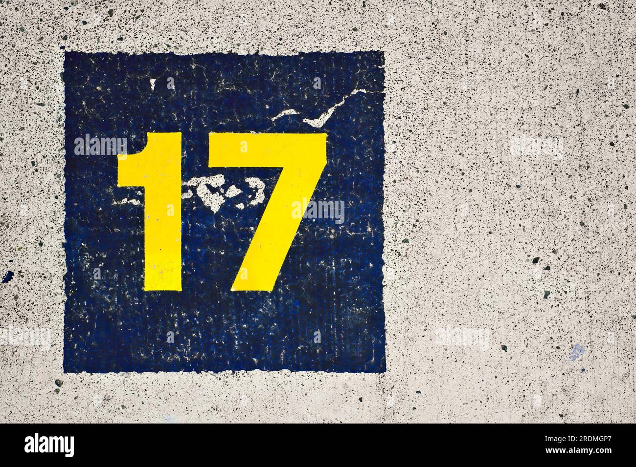 Number 17, seventeen, yellow and blue paint on grey background Stock ...