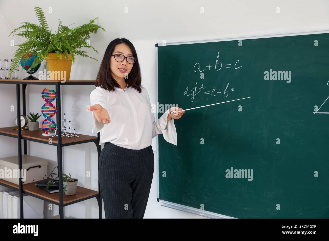Female Asian teacher conducting Math near chalkboard in classroom Stock ...
