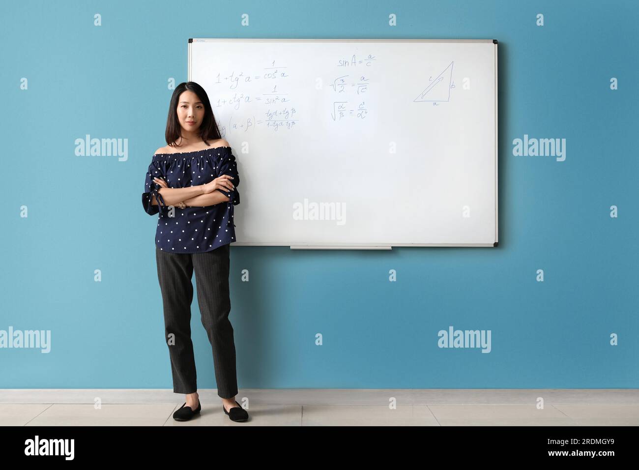 Asian Math teacher near flipboard in classroom Stock Photo - Alamy