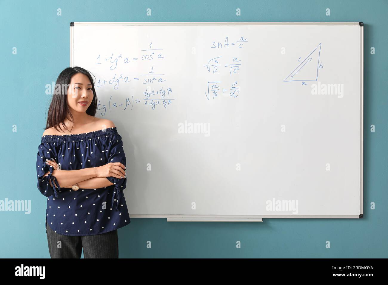 Asian Math teacher near flipboard in classroom Stock Photo - Alamy
