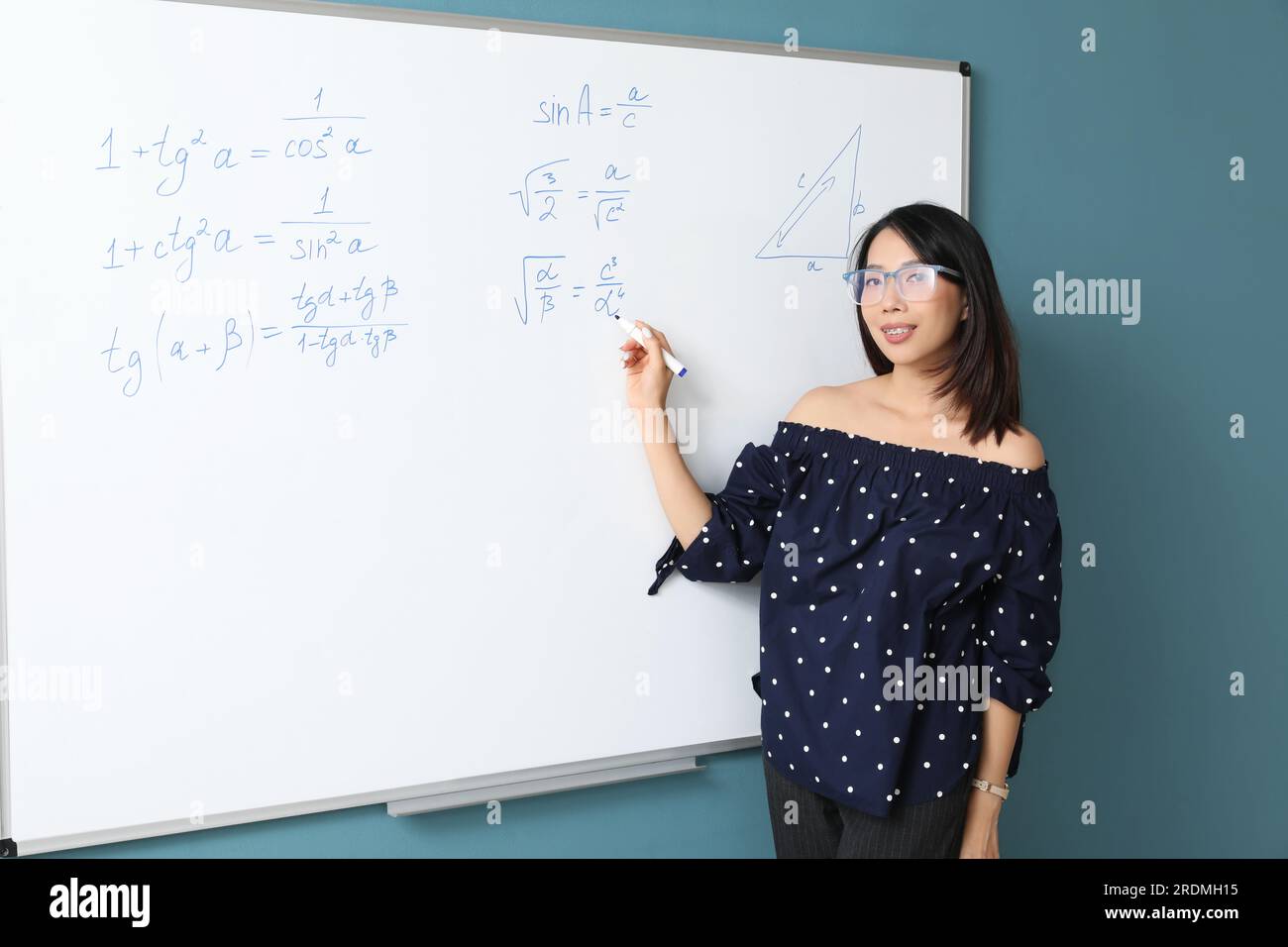 Asian Math teacher near flipboard in classroom Stock Photo - Alamy