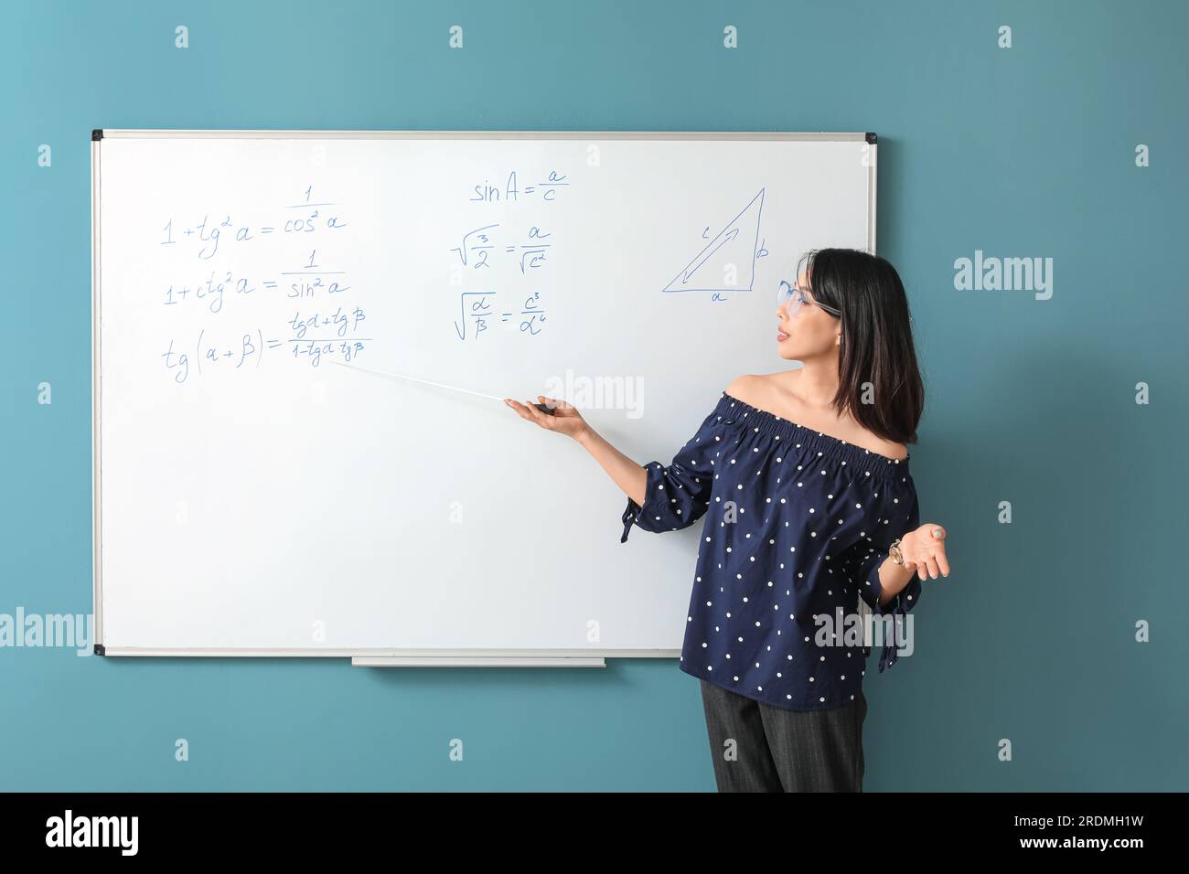 Asian Math teacher near flipboard in classroom Stock Photo - Alamy