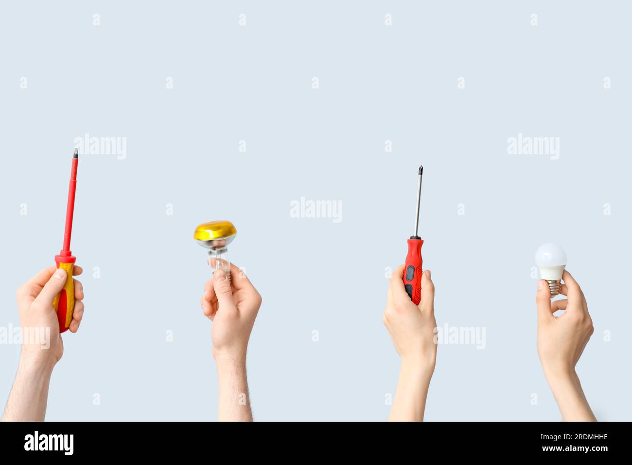 Electrician hands with light bulbs and tools on grey background Stock ...