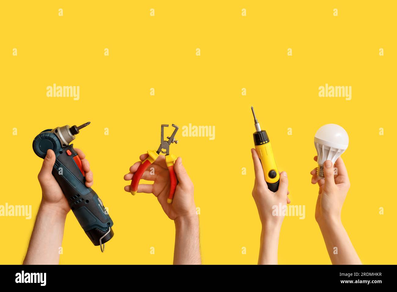 Electrician hands with light bulb and tools on yellow background Stock ...