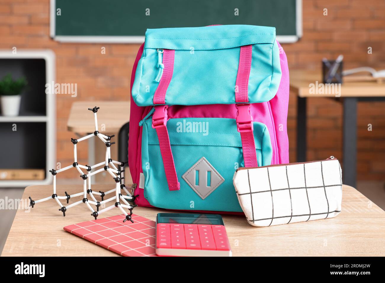 Colorful school backpack with stationery and molecular model on desk in ...