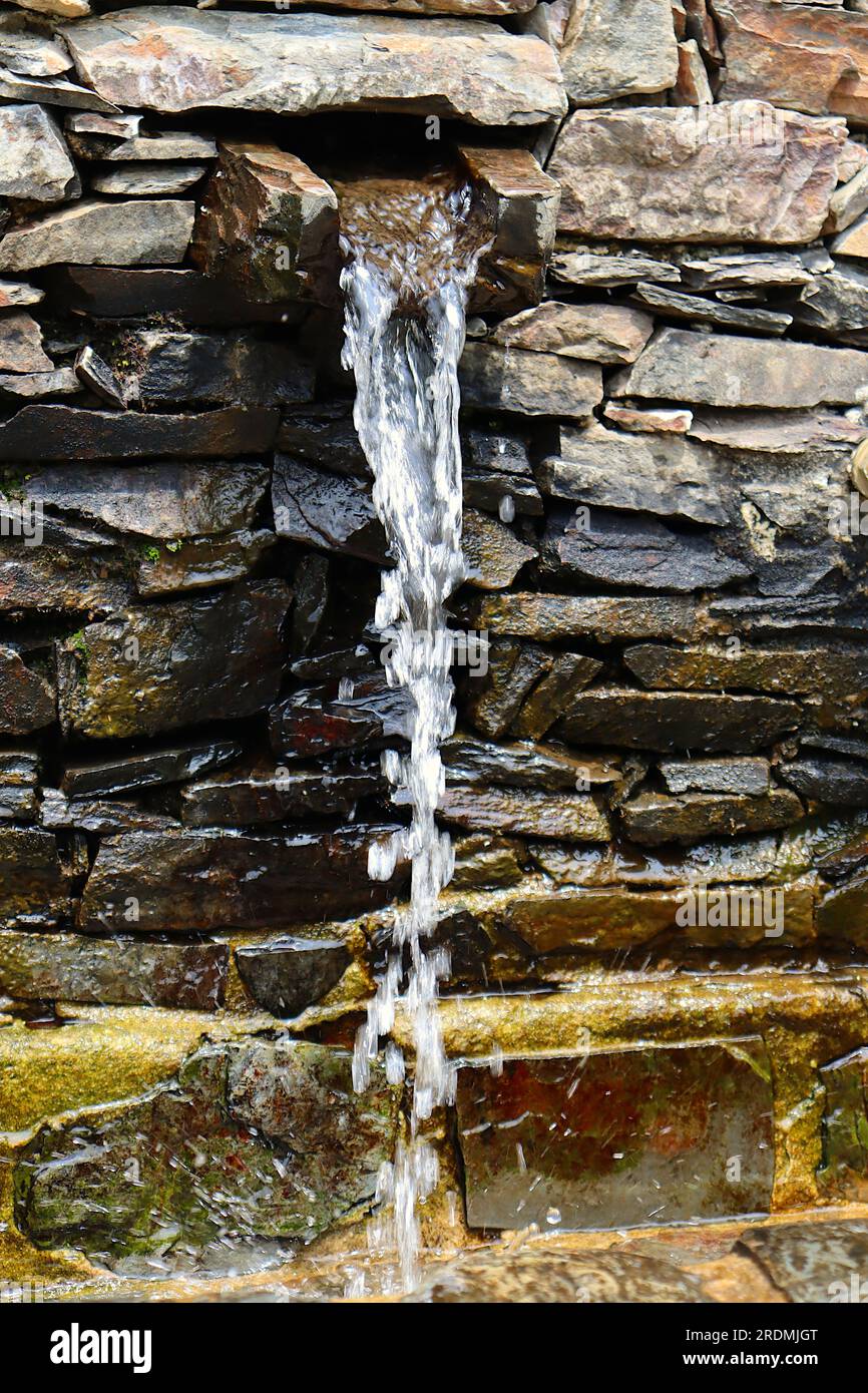 Water fountain running on a stone wall Stock Photo - Alamy