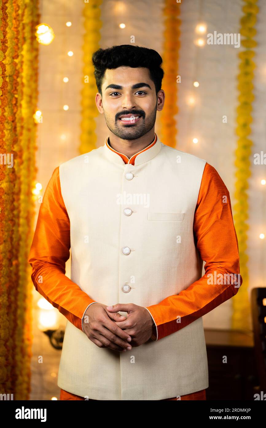 Vertical shot of happy indian young man standing with in traditional ...